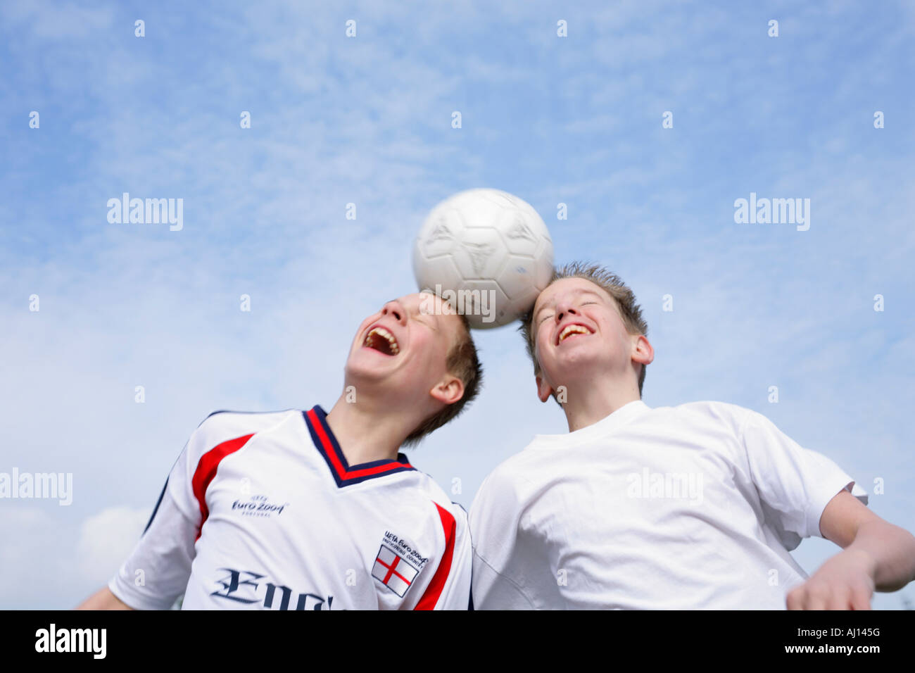 two teenage boys are trying to head a ball at the same time Stock Photo ...