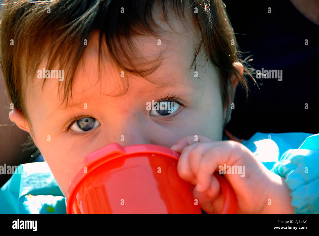 9 month baby girl drinking from red plastic beaker Stock Photo - Alamy