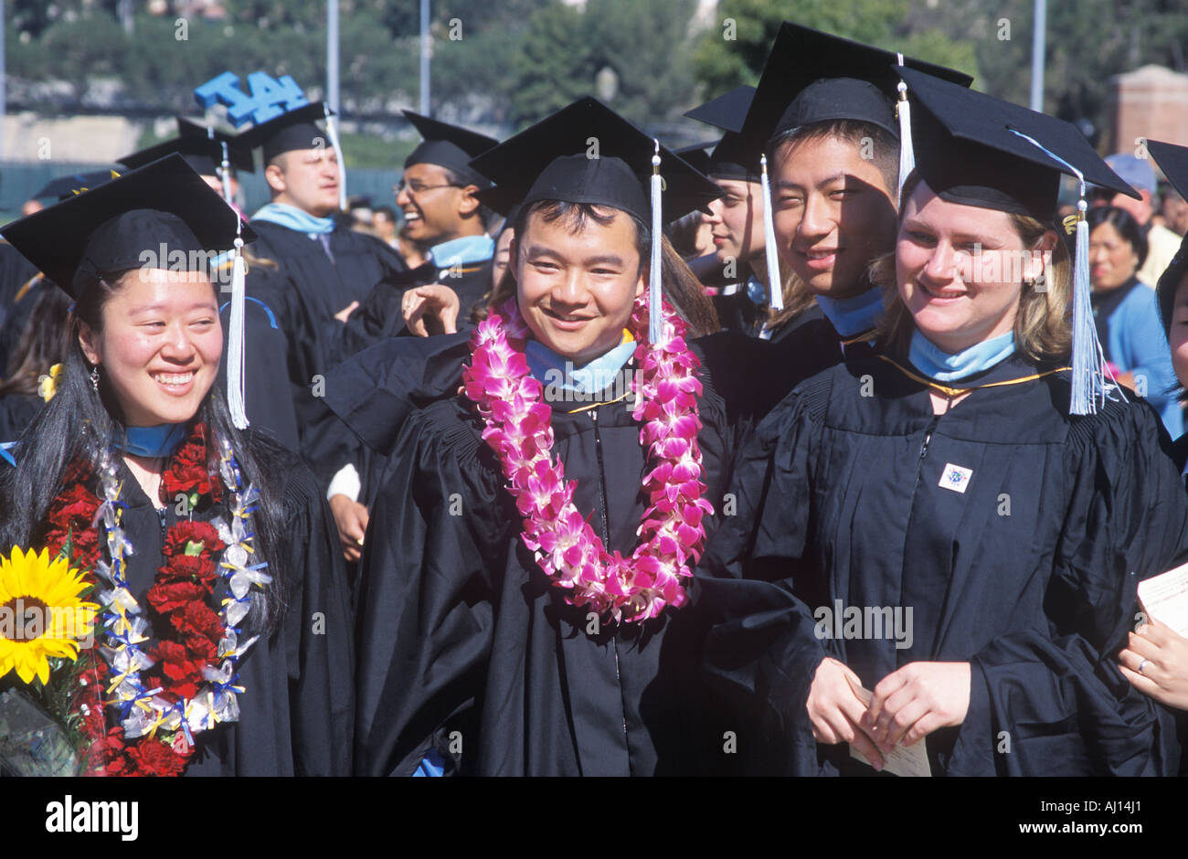 Graduates march across the stadium field at the University of ...