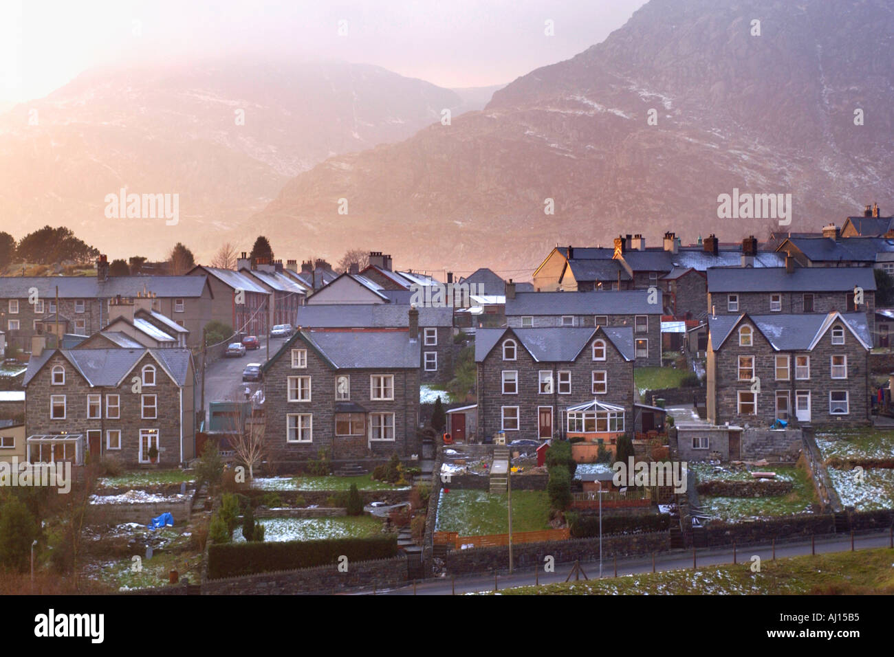 Tips of slate waste from old quarries rise up behind houses in Blaenau ...