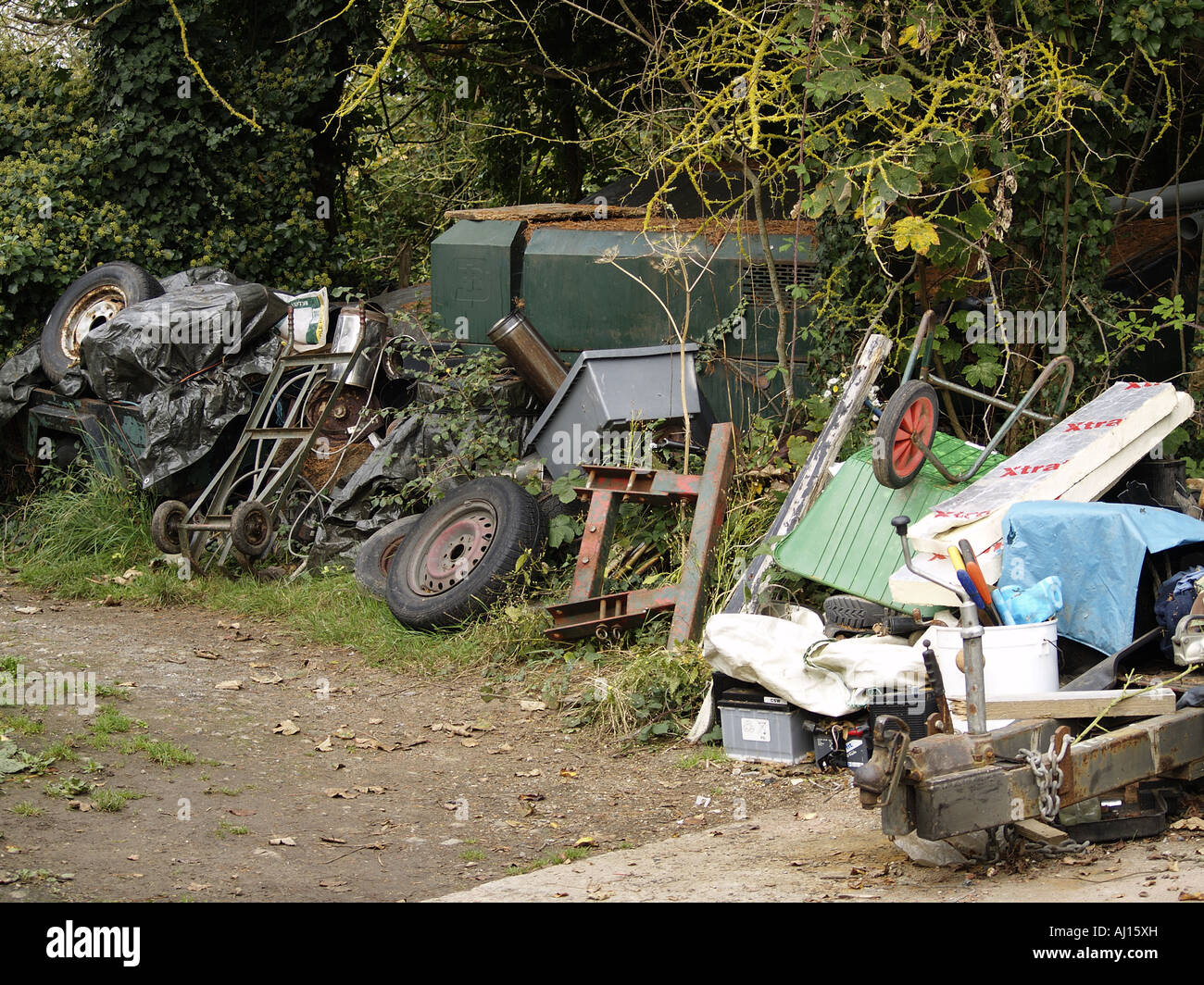 Piles of junk under a hedge Stock Photo - Alamy