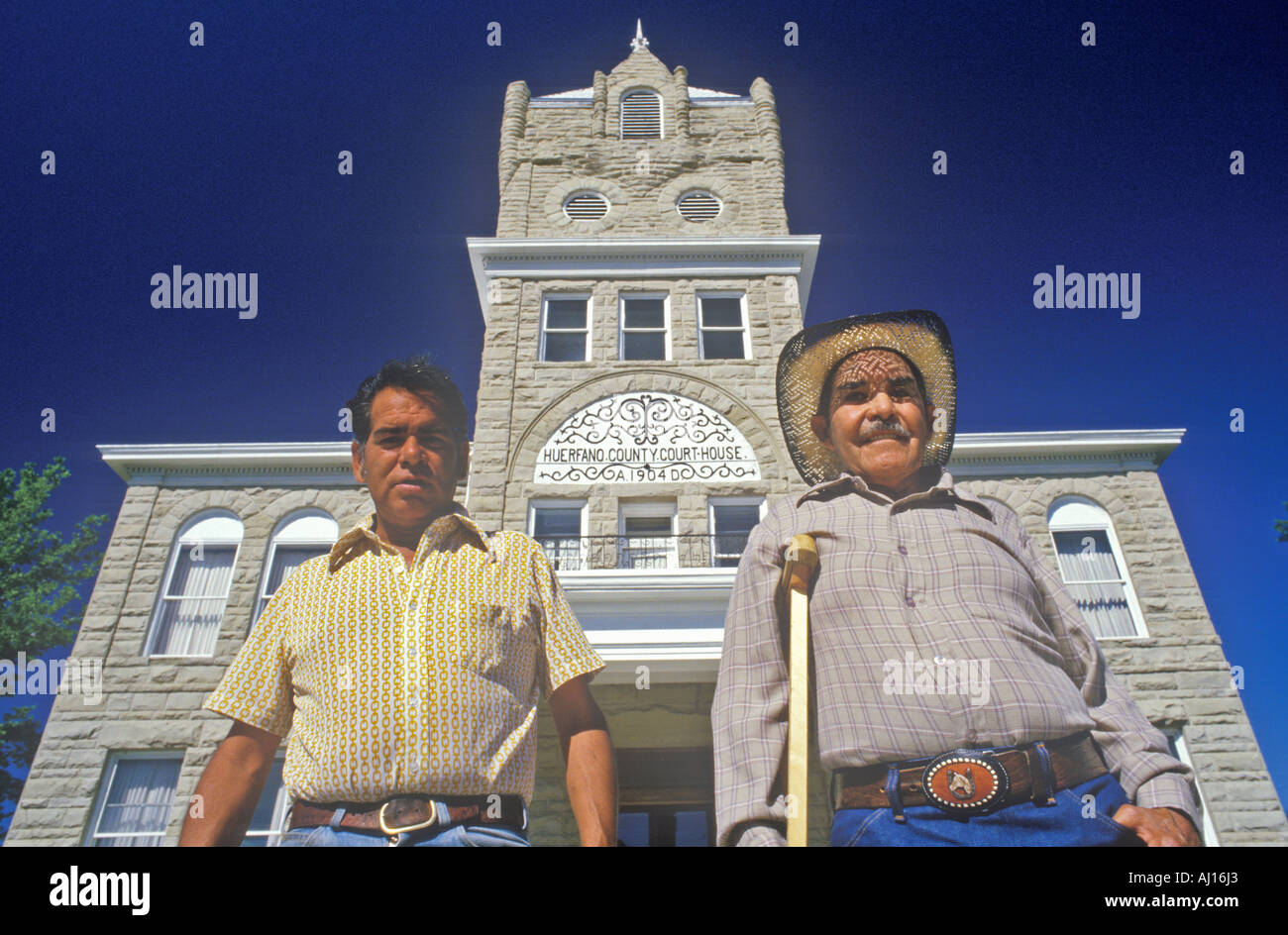 Two Mexican American gentlemen one with crutch in front of Huerfano ...