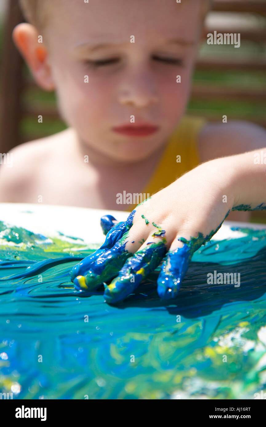 little boy painting with finger colours Stock Photo - Alamy