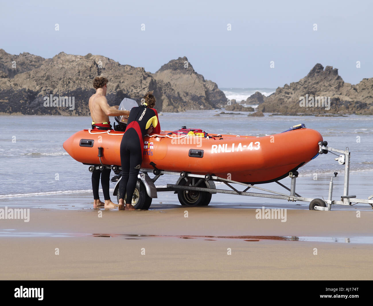 Two lifeguards with an RNLI inshore lifeboat Stock Photo - Alamy