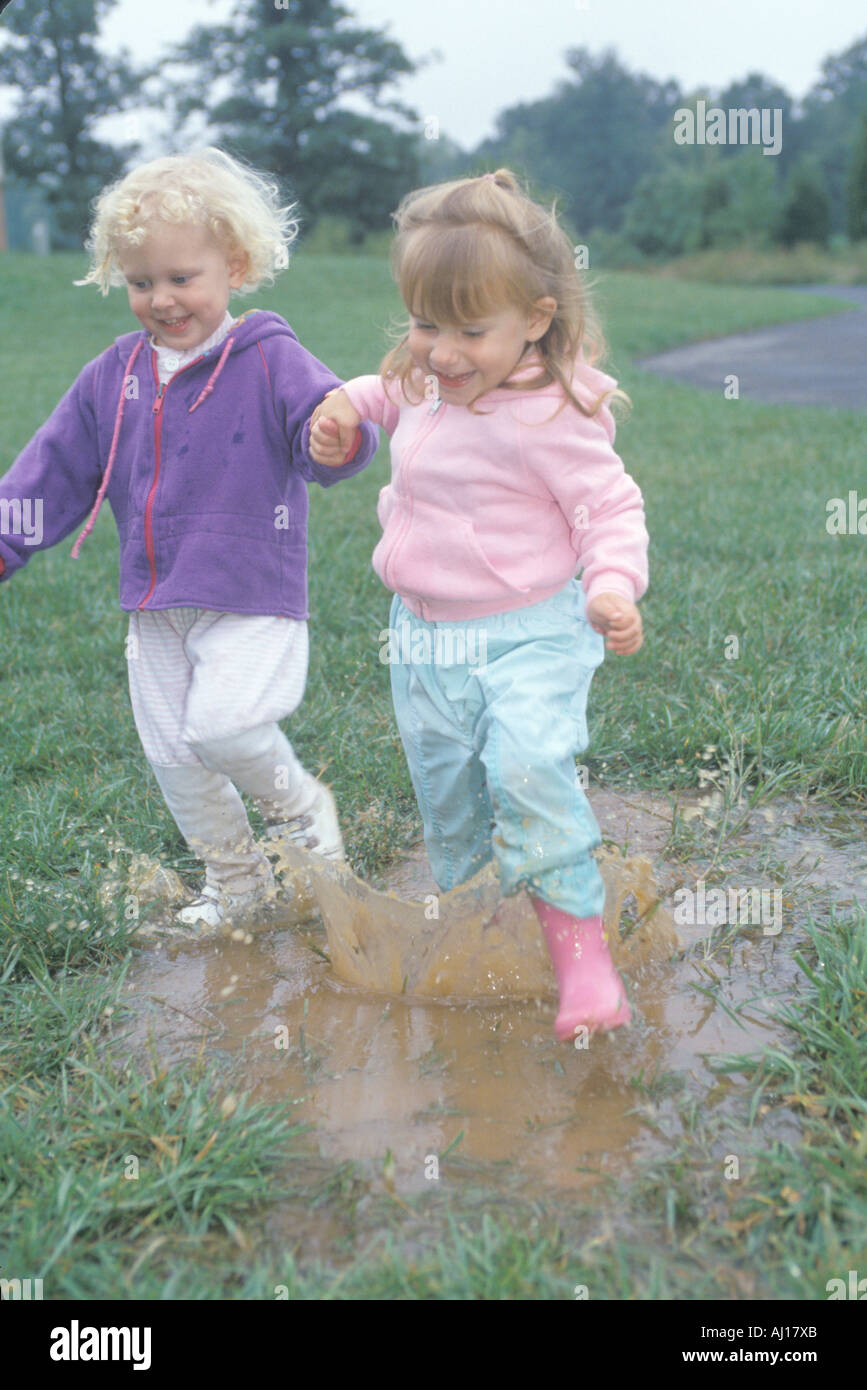 Two children jumping over a puddle Washington D C Stock Photo - Alamy