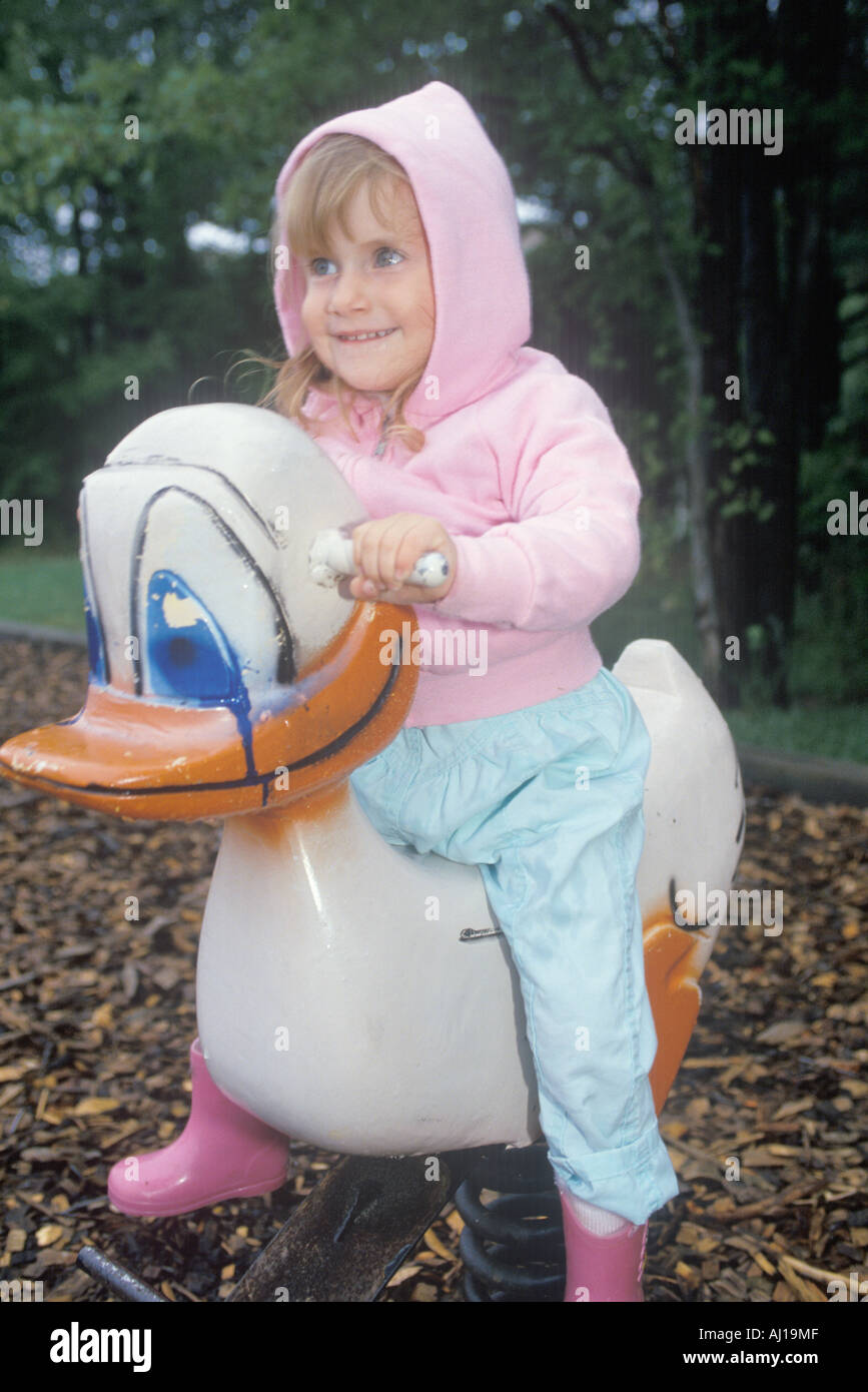 A preschool girl sitting on a duck ride Stock Photo - Alamy