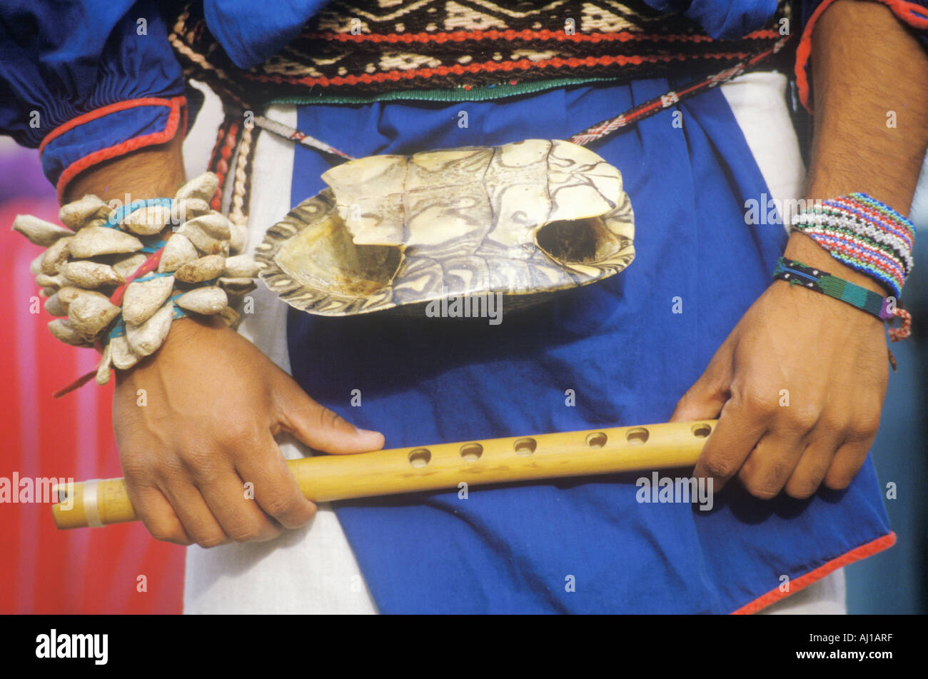 Close up of turtle shell worn on the waist of a man holding flute ...
