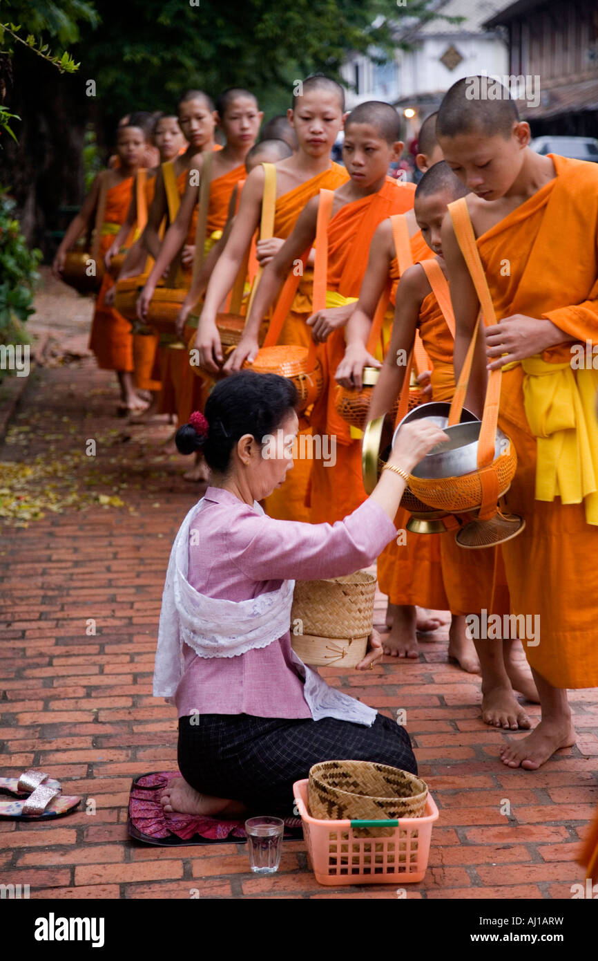 Local women give rice Alms to novice monks in Luang Prabang Laos Stock ...