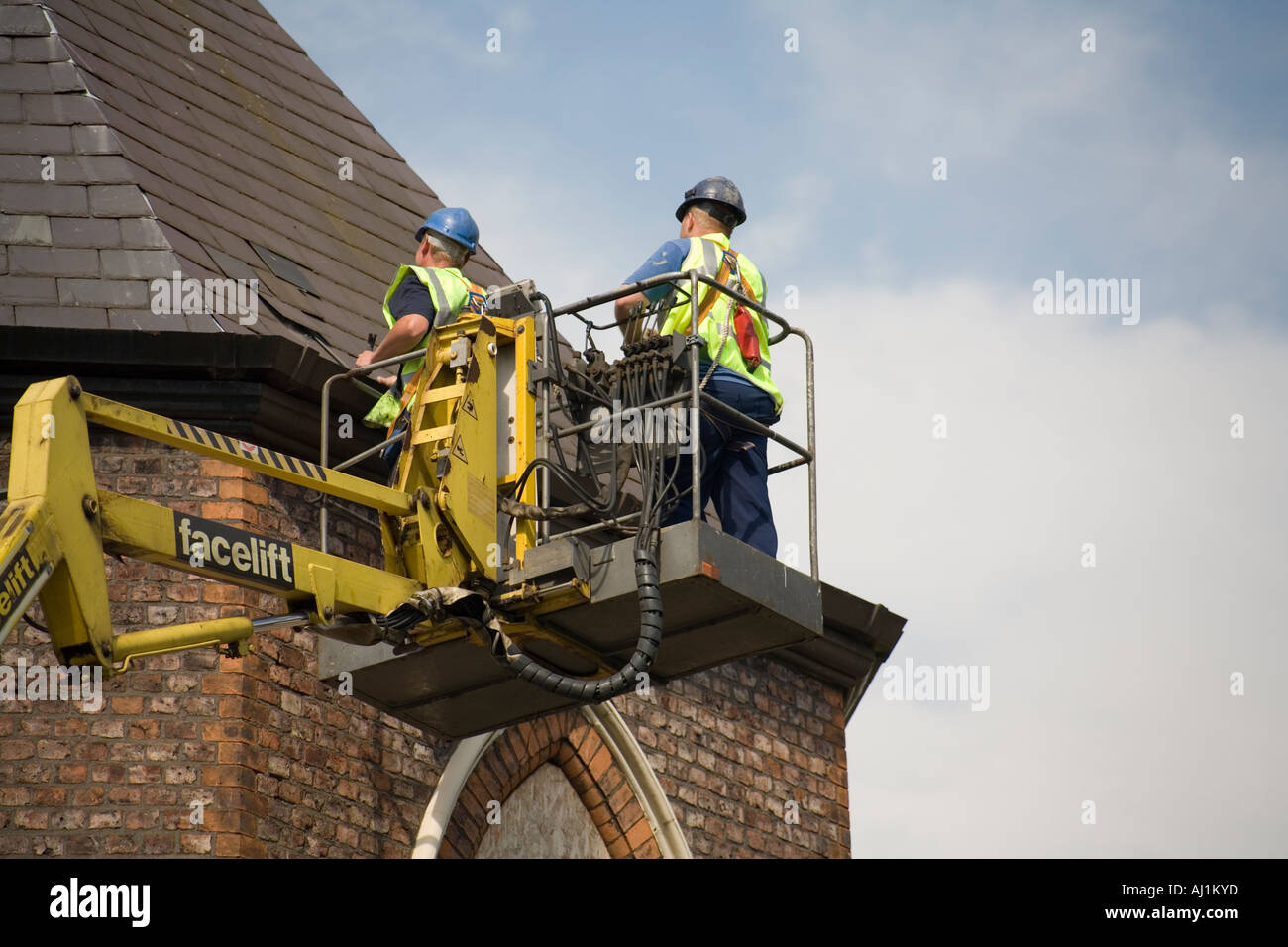 Working men on a mechanical platform UK fixing a roof Stock Photo - Alamy