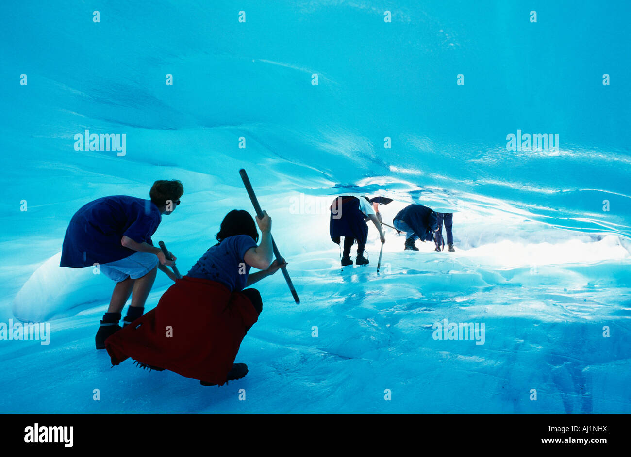 Hikers walking through ice hole, Fox Glacier, New Zealand Stock Photo ...