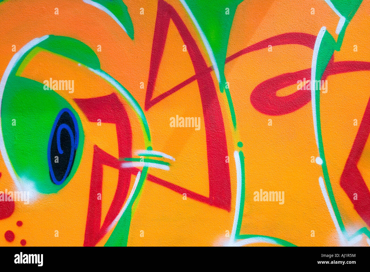 Orange red and green graffiti pattern on a textured wall Stock Photo ...
