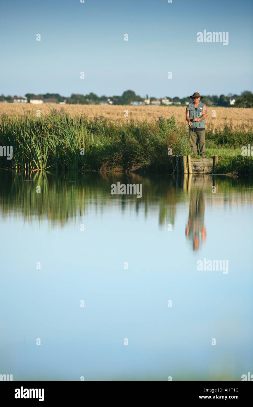 man fly fishing on smooth calm lake with reflection Stock Photo - Alamy