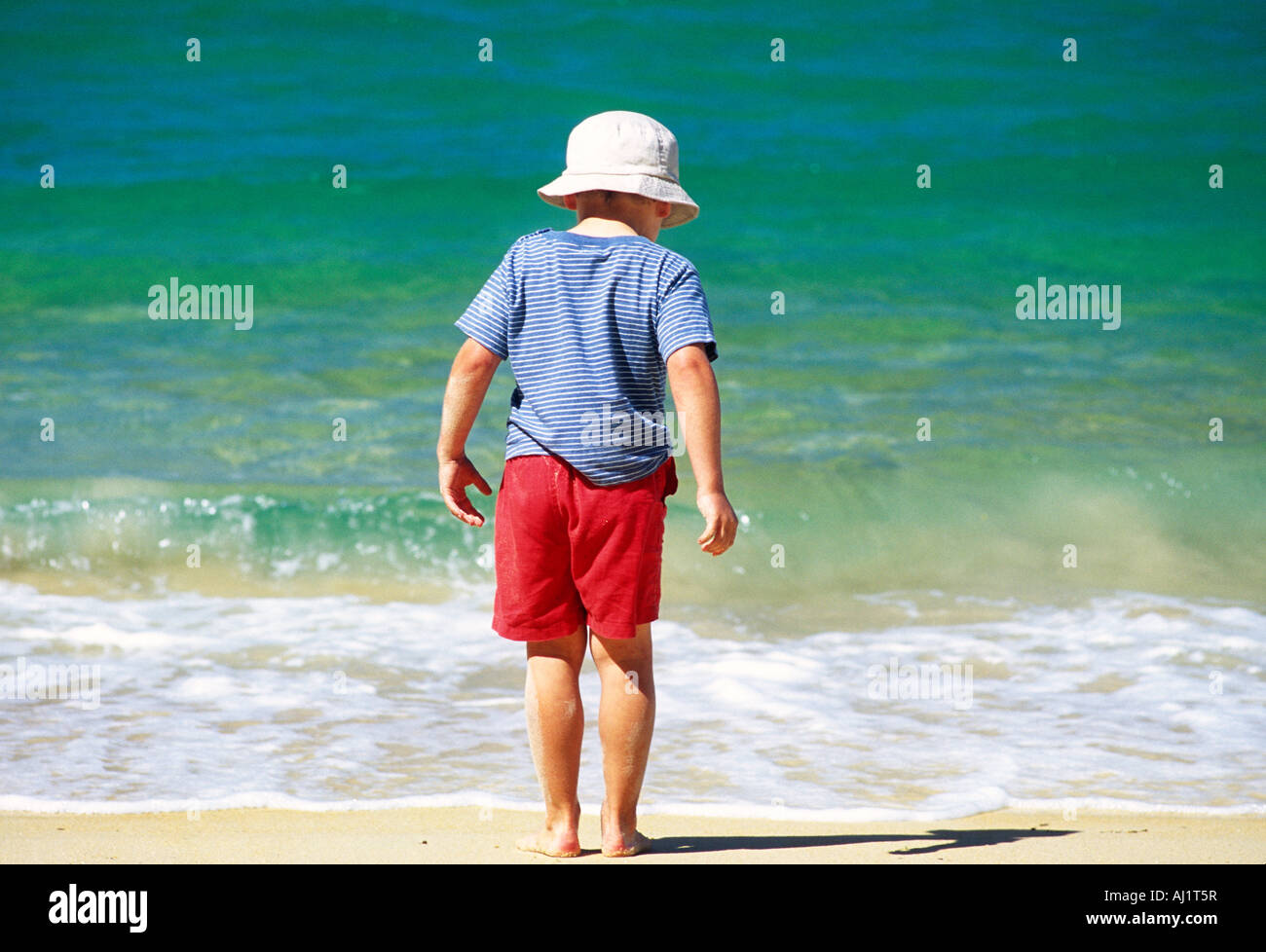 young boy on beach watching sea Stock Photo - Alamy