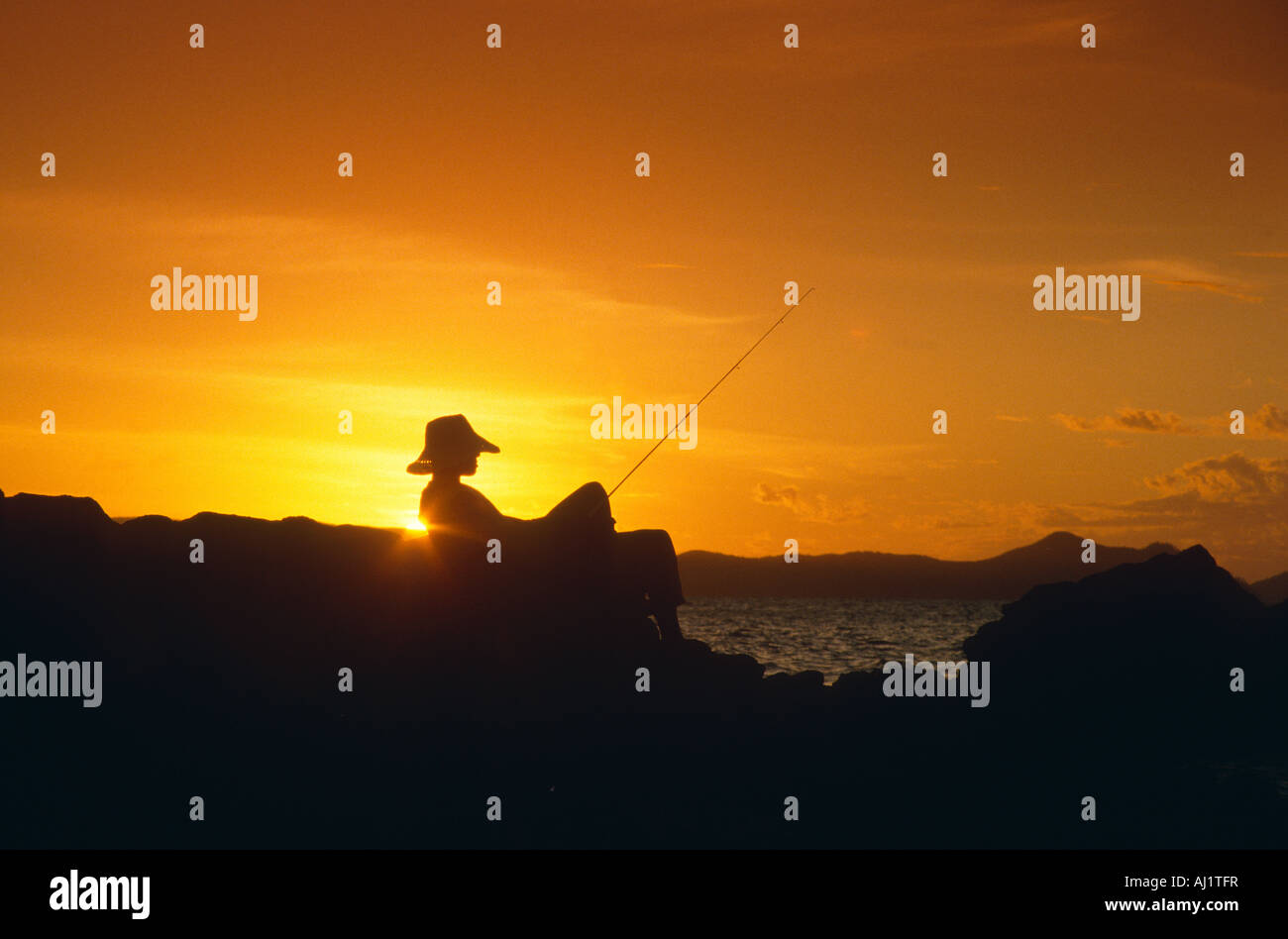 young man fishing at sunset Stock Photo - Alamy