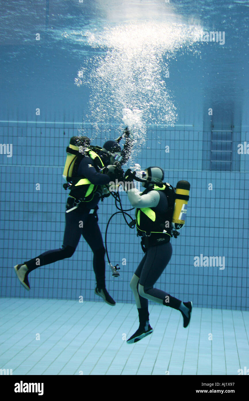 Rescue diver of a fire brigade at a training in a swimming pool in ...