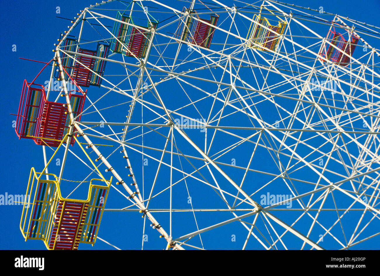 empty Ferris wheel with blue sky and coloured seats Stock Photo - Alamy