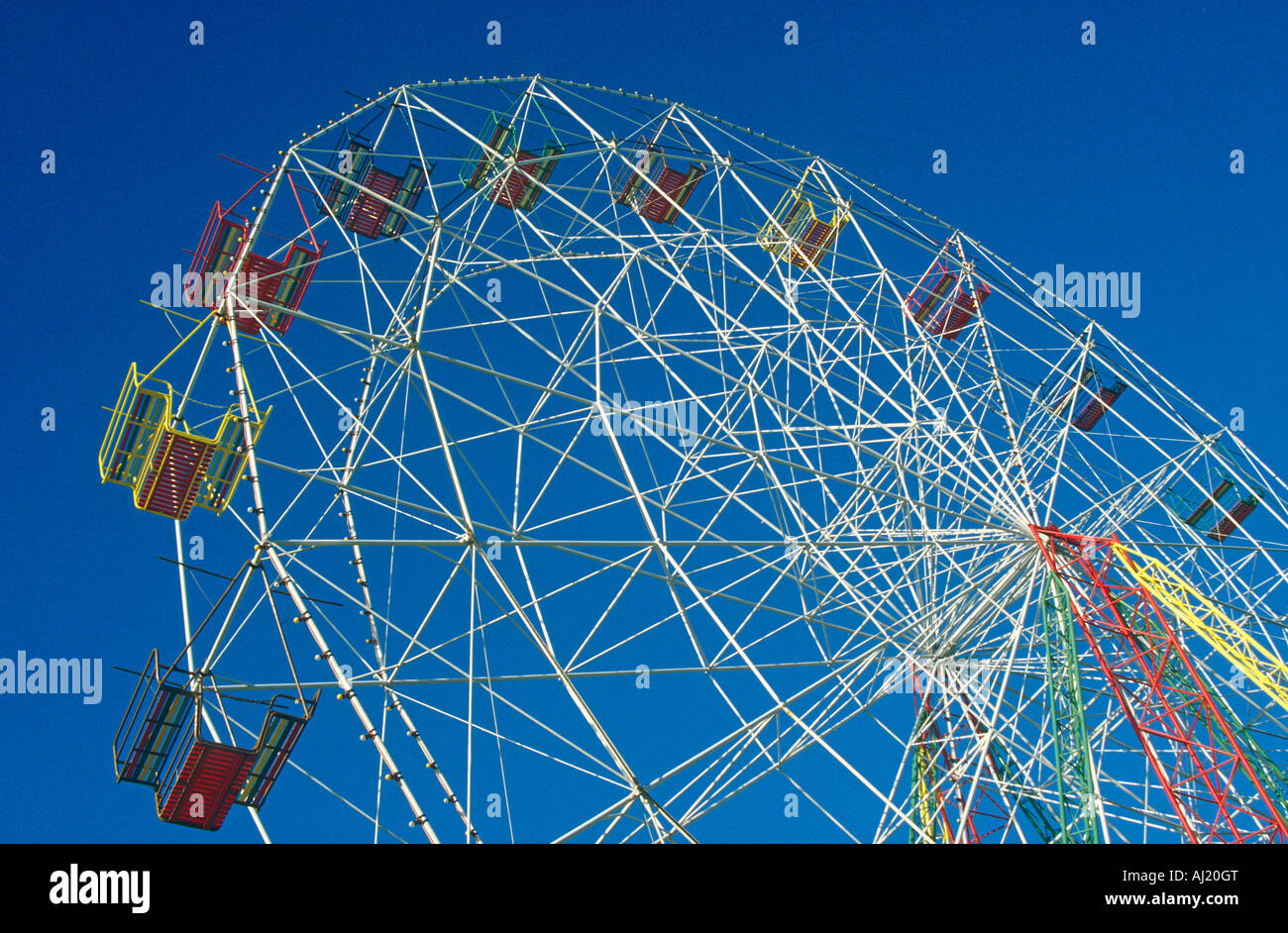 empty Ferris wheel with blue sky and coloured seats Stock Photo - Alamy