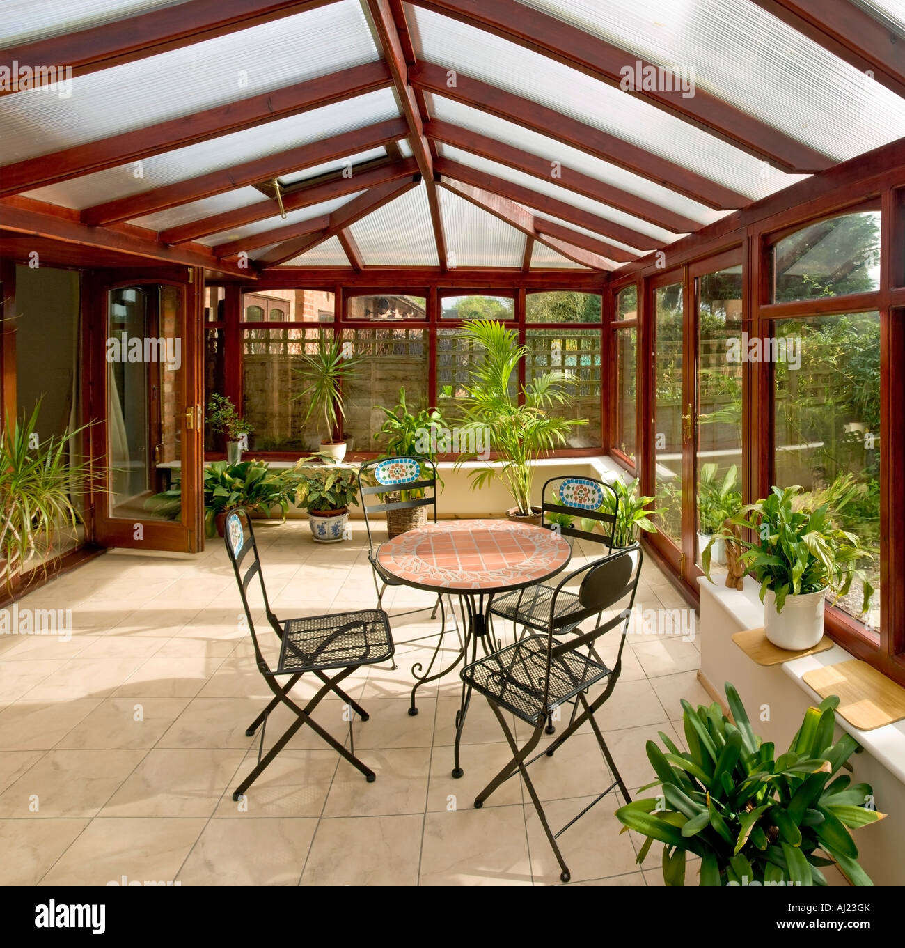 conservatory tables chairs plants room in house next to garden Stock ...