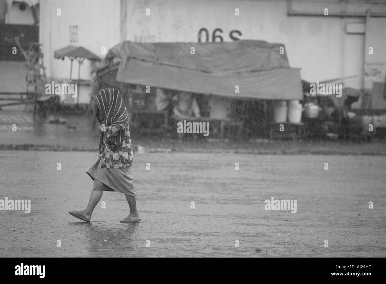 Indonesia Jakarta Young man running through rain storm at Old Harbor at ...
