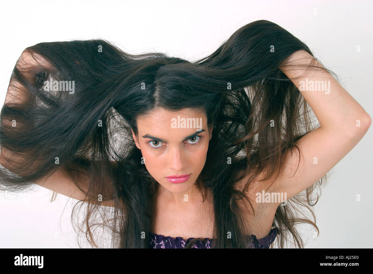 Slightly angry young woman speading her long hair with her hands Stock ...