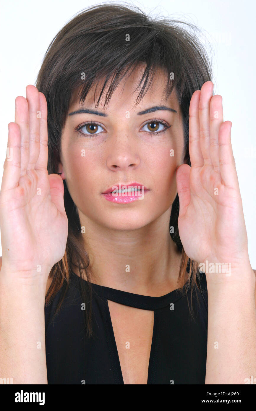 Young woman with black evening dress and hands alongside her eyes ...
