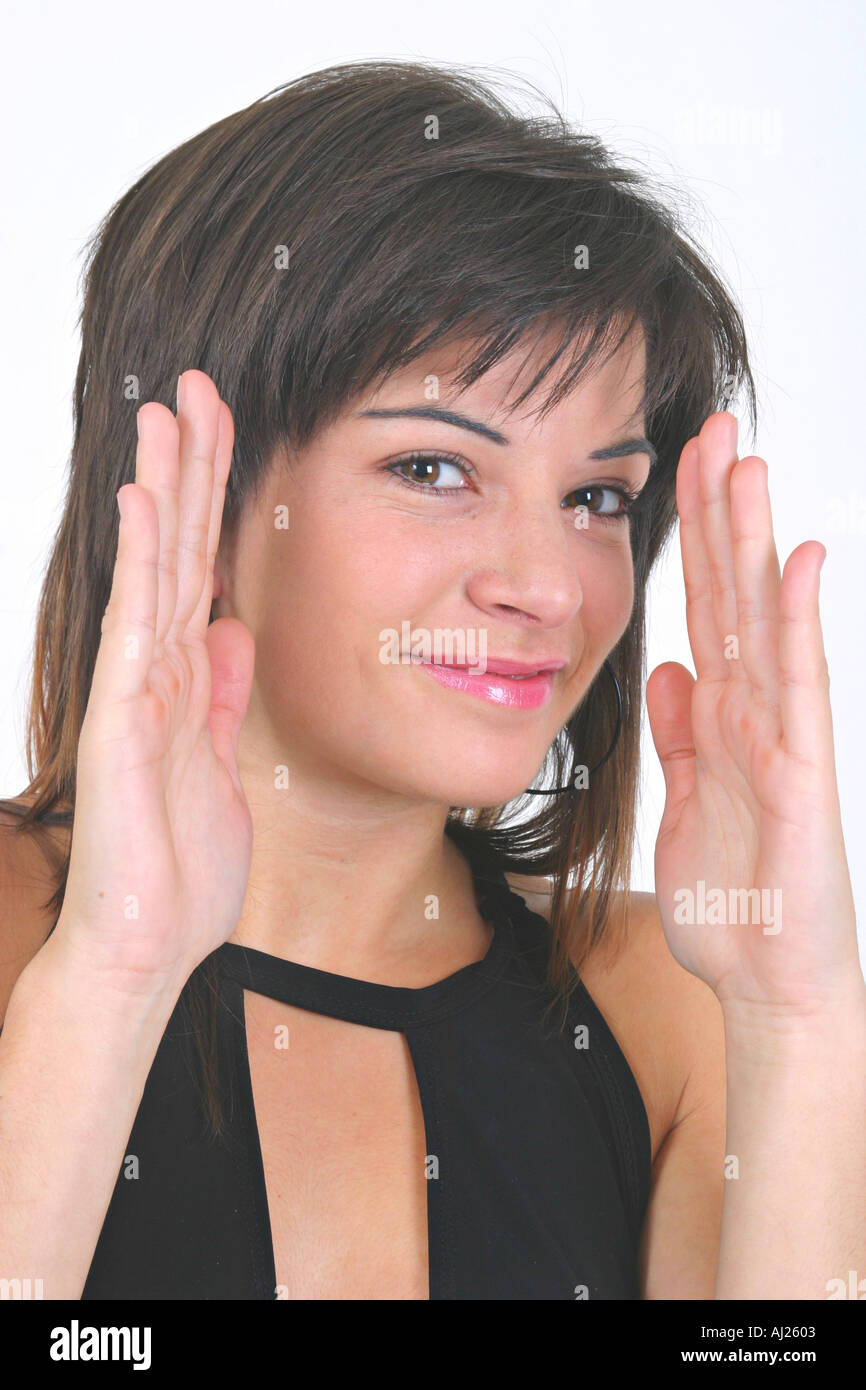 Young woman with black evening dress and hands beside her eyes smiling ...