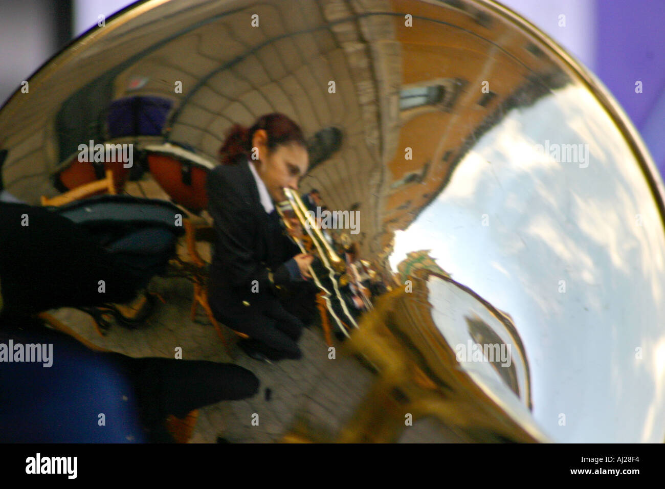 Reflection of a young musician on the bell of a metal instrument ...