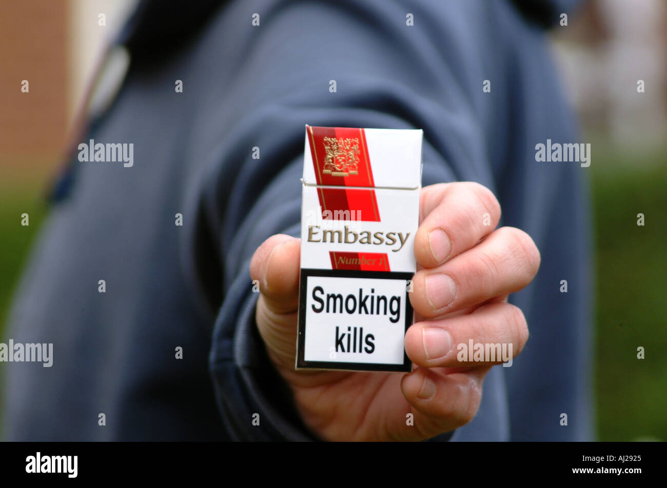A man holding a cigarette box with the warning smoking kills Stock ...
