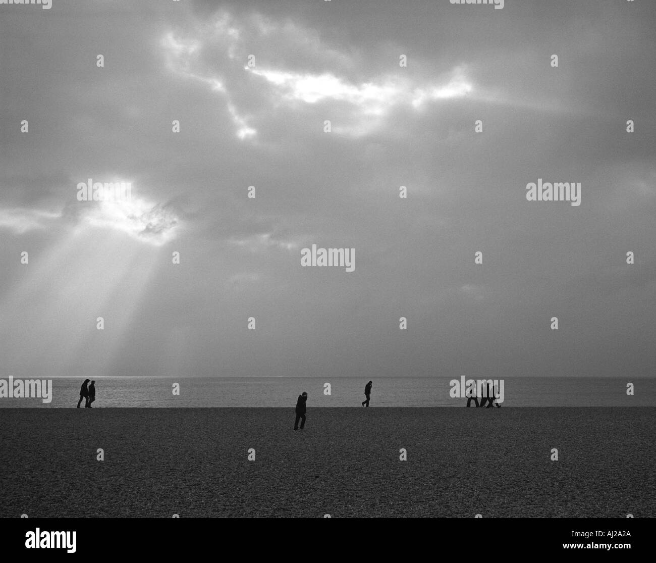 Monochrome group of people walking on Brighton beach Stock Photo - Alamy