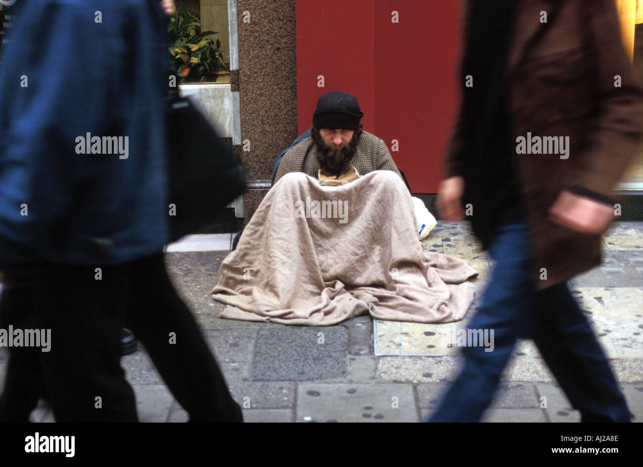 People passing homeless man begging on street, London, England, UK ...