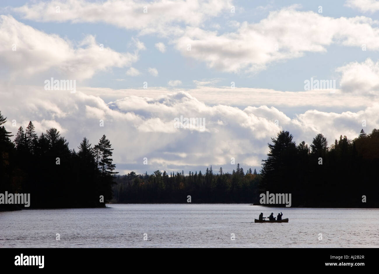 Algonquin Provincial Park Ontario Three canoers paddle a canoe on Rain ...