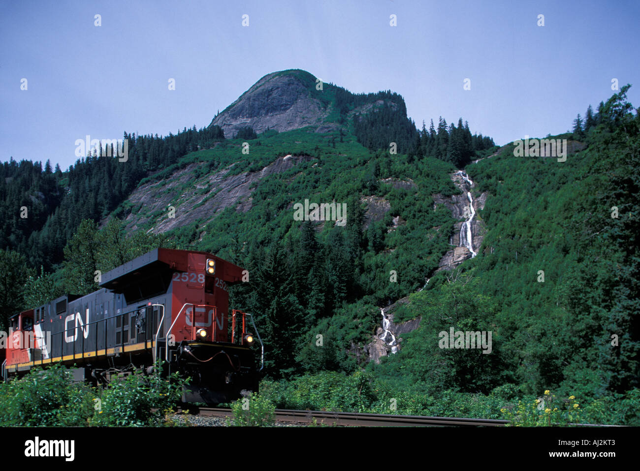 Canada British Columbia CN Rail freight train motors past waterfall ...