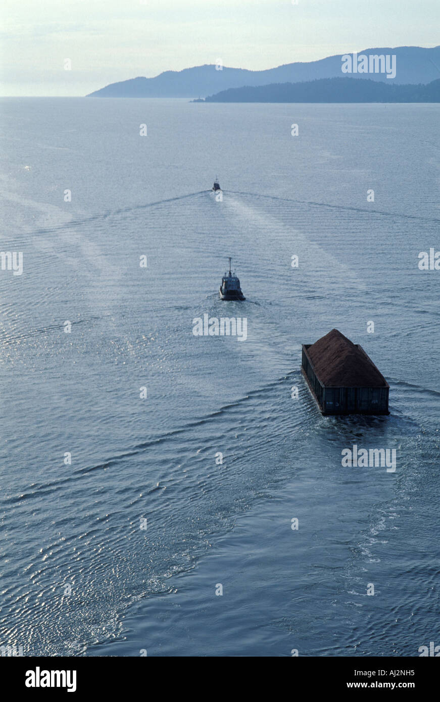 Canada British Columbia Tugboat pulls barge filled with wood chips ...
