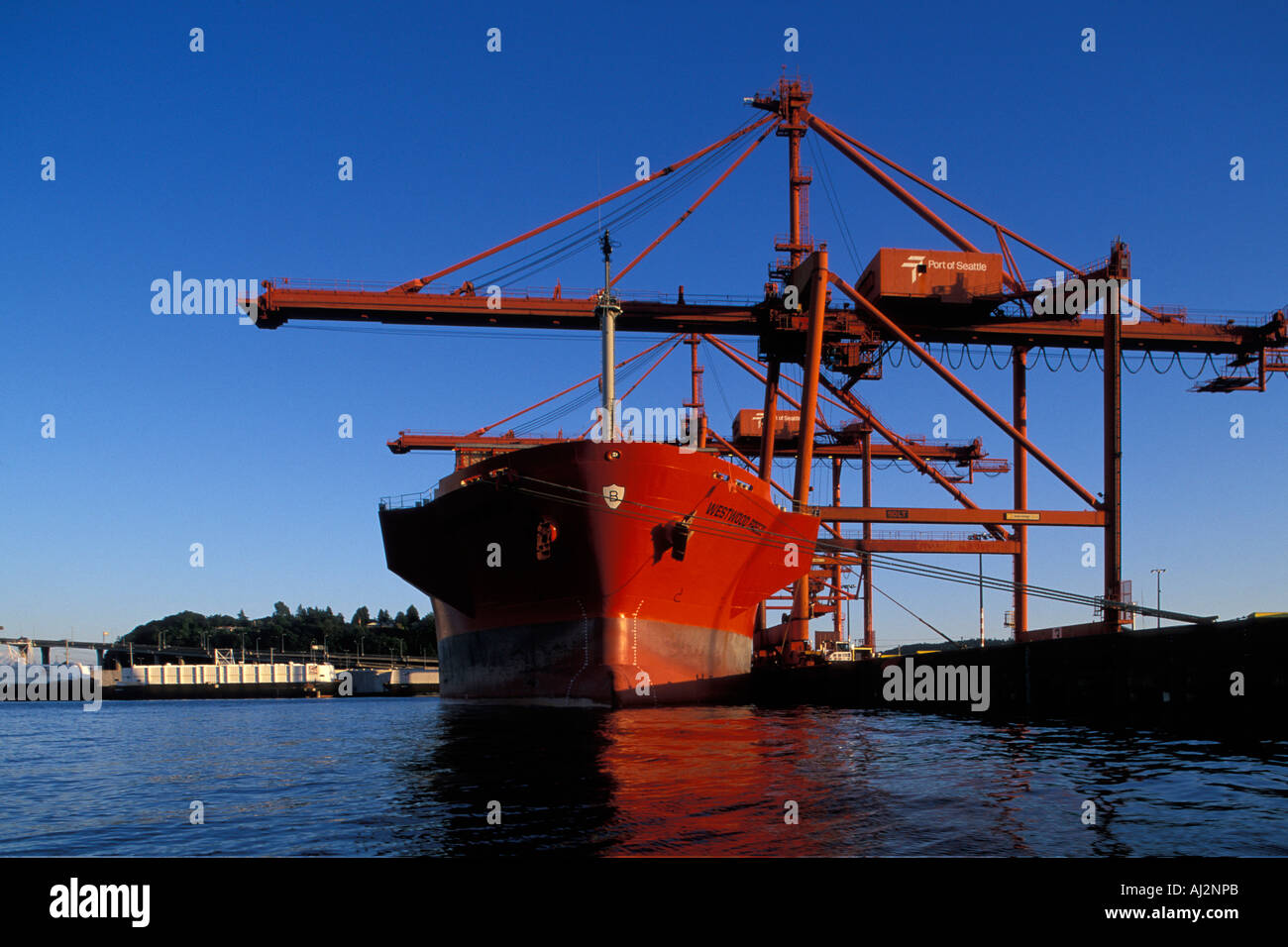 USA Washington Seattle Setting sun lights cargo ship being loaded with ...