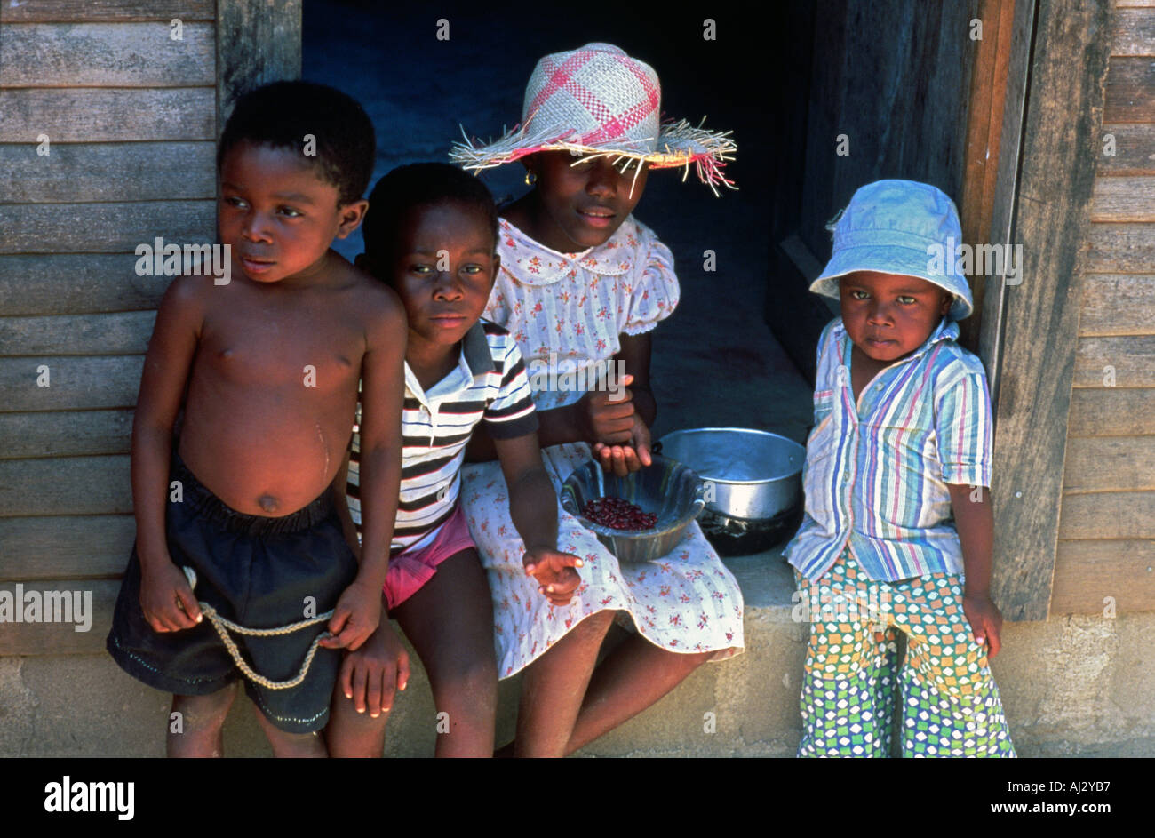 A portrait of Garifuna children outside their wooden house in their ...