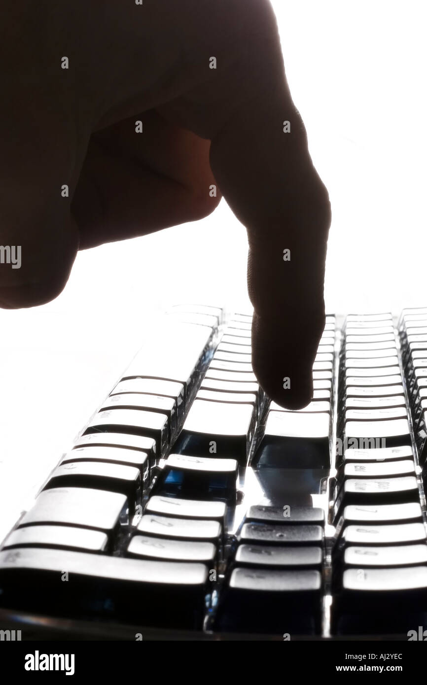 Finger pressing a key on a computer keyboard Stock Photo - Alamy