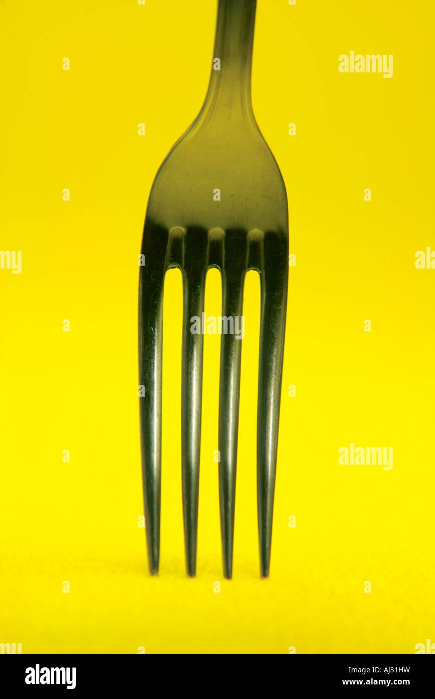creative concept gourmet fork detail in yellow background vertical ...