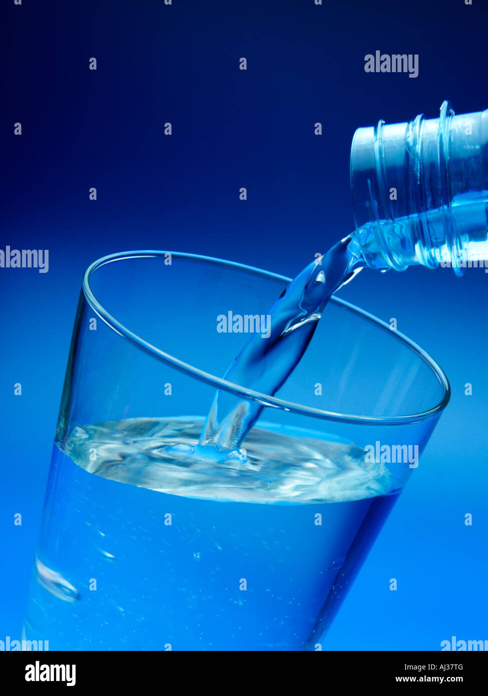 A bottle pouring mineral water into a glass Stock Photo - Alamy