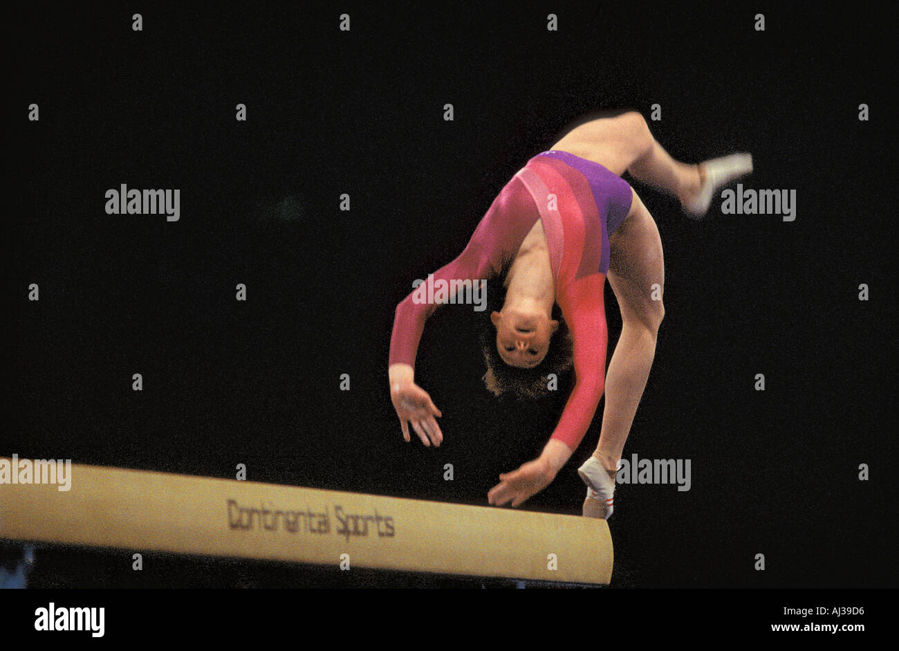 Woman gymnast doing a somersault during competition on the Beam Stock ...