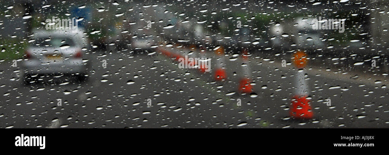 Cars passing road works on the motorway in heavy rain Stock Photo - Alamy
