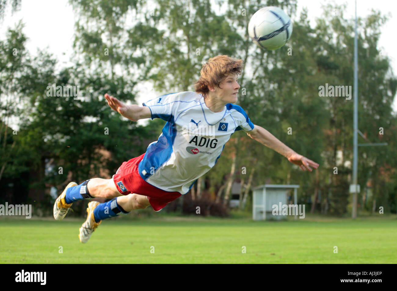 teenage boy jumping to head a football at soccer practise Stock Photo ...