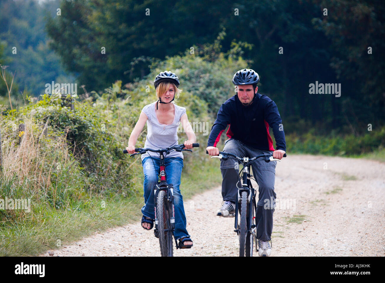 Two cyclists ride along an off road track near Witchampton Dorset Stock ...