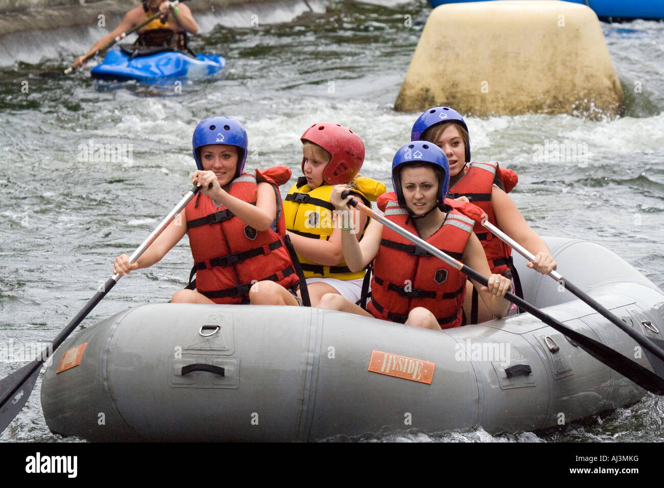 Group of girls in a boat floating down whitewater river rapids Stock ...
