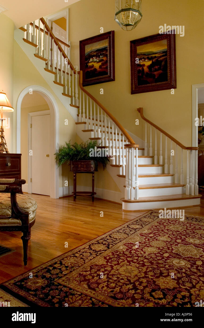 Inviting entry foyer with staircase and artwork Stock Photo - Alamy