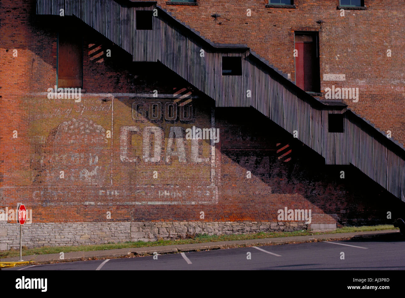 A faded sign for Good Coal along a red brick industrial building in ...