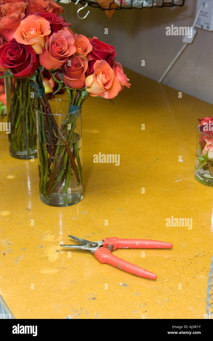 Flowers and cutting tool on counter in florist workroom Stock Photo - Alamy