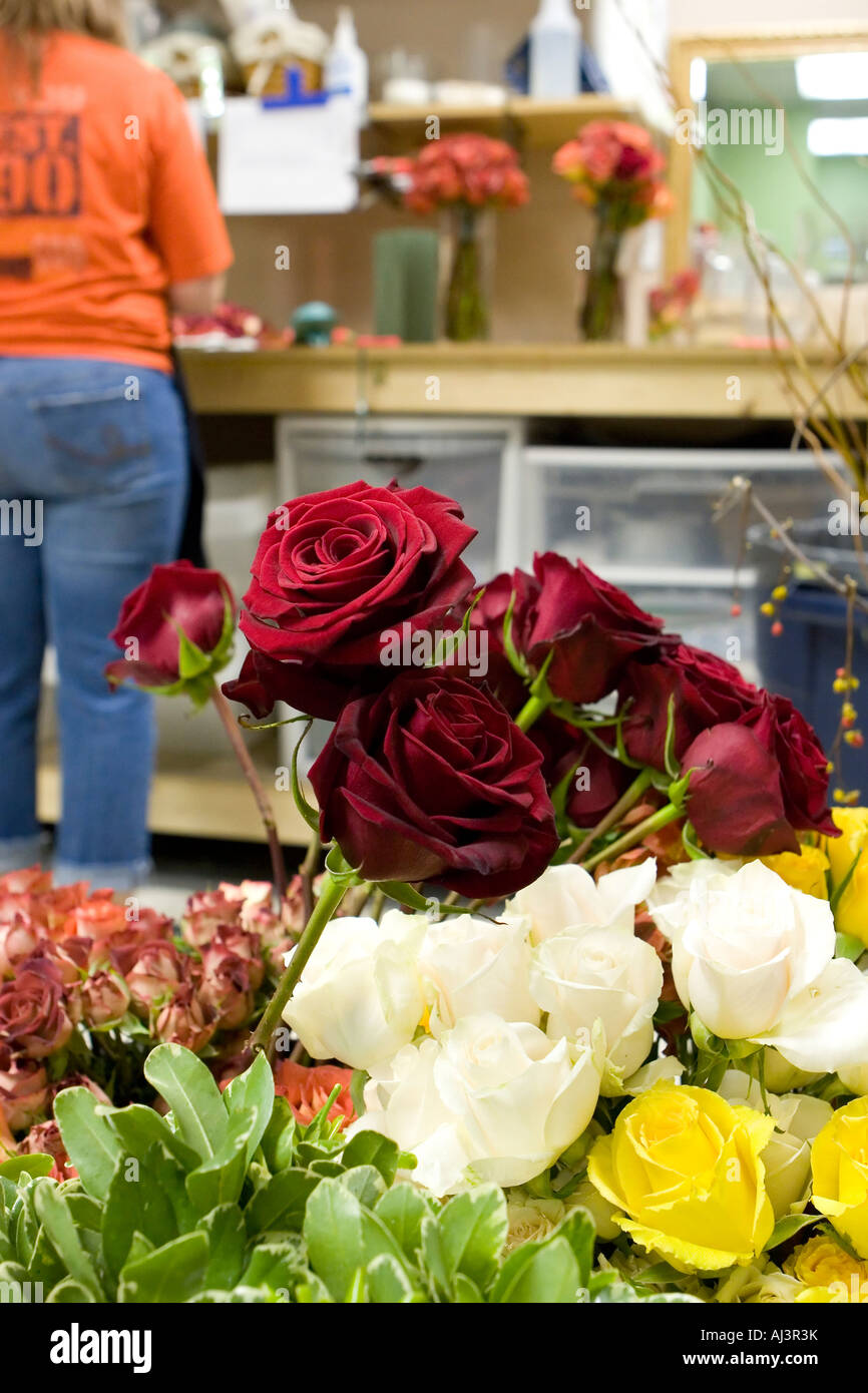 Florist works on creating a rose bouquet in the background. Unused ...