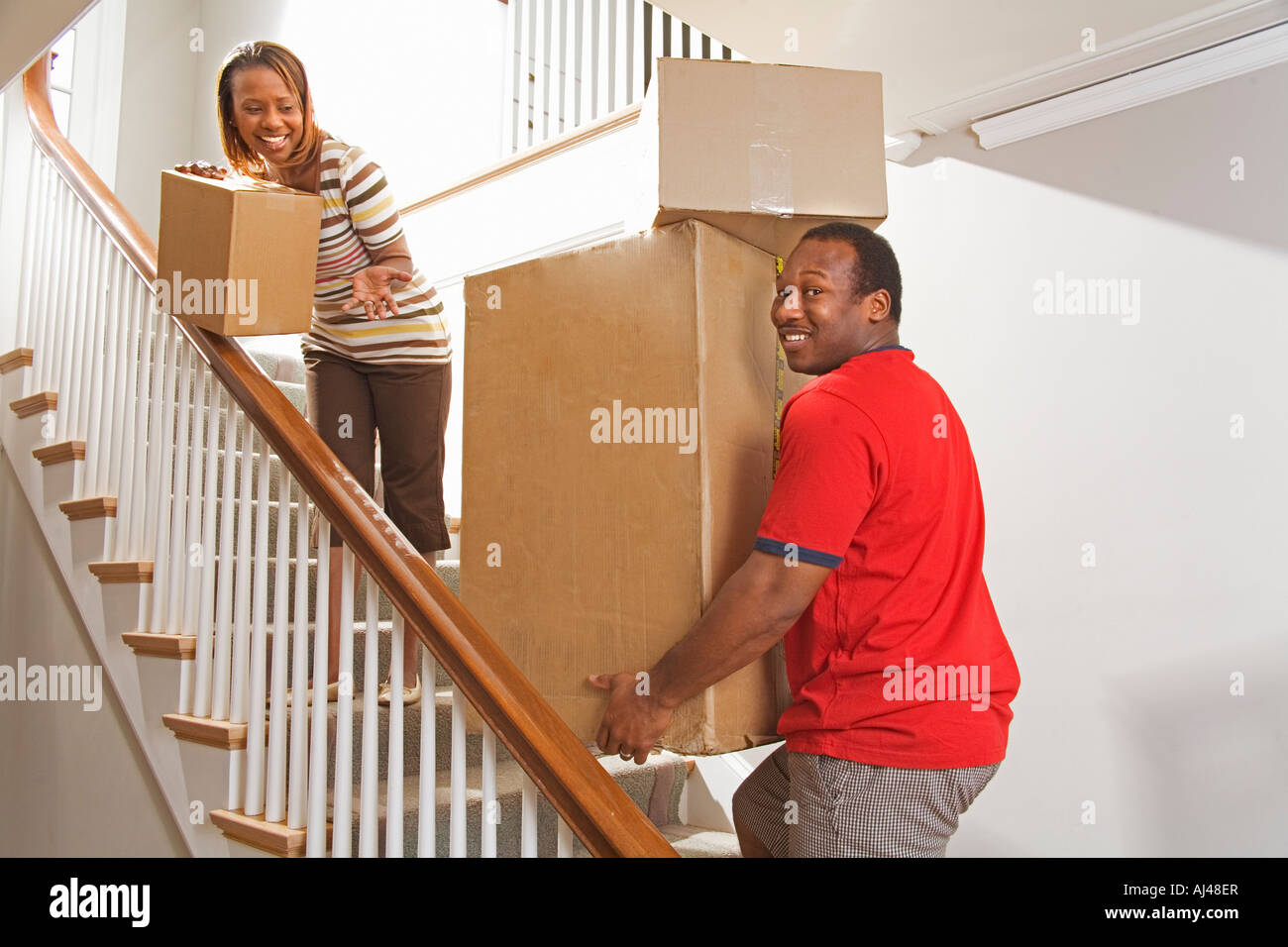 African couple carrying moving boxes Stock Photo - Alamy
