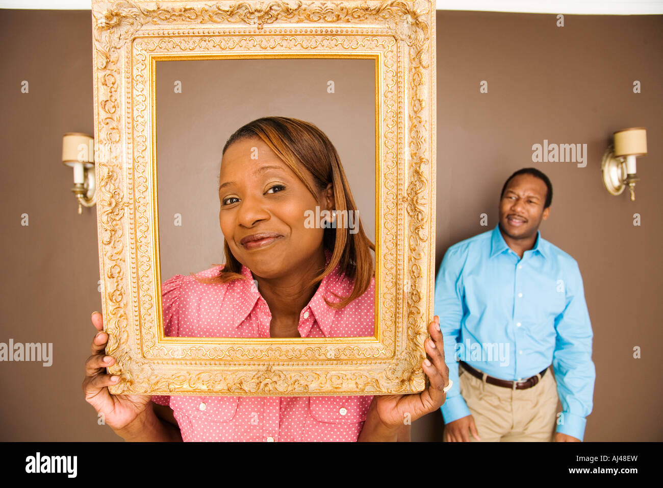 African woman looking through picture frame Stock Photo - Alamy