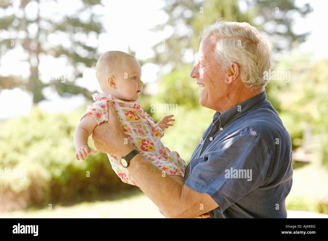 Senior man holding baby Stock Photo - Alamy
